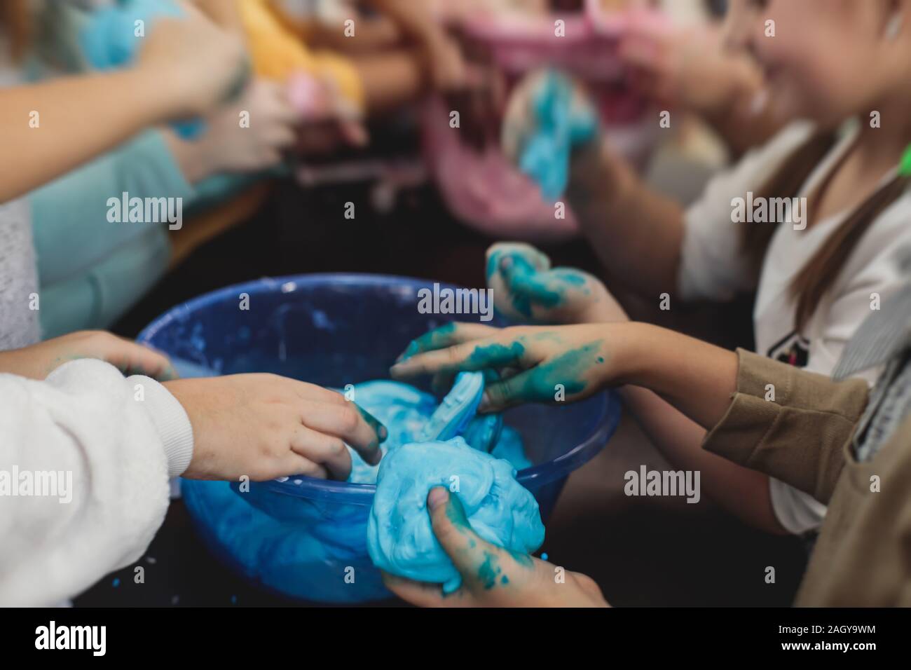 Group of kids making a multicoloured slime, pink, blue and white slime ...