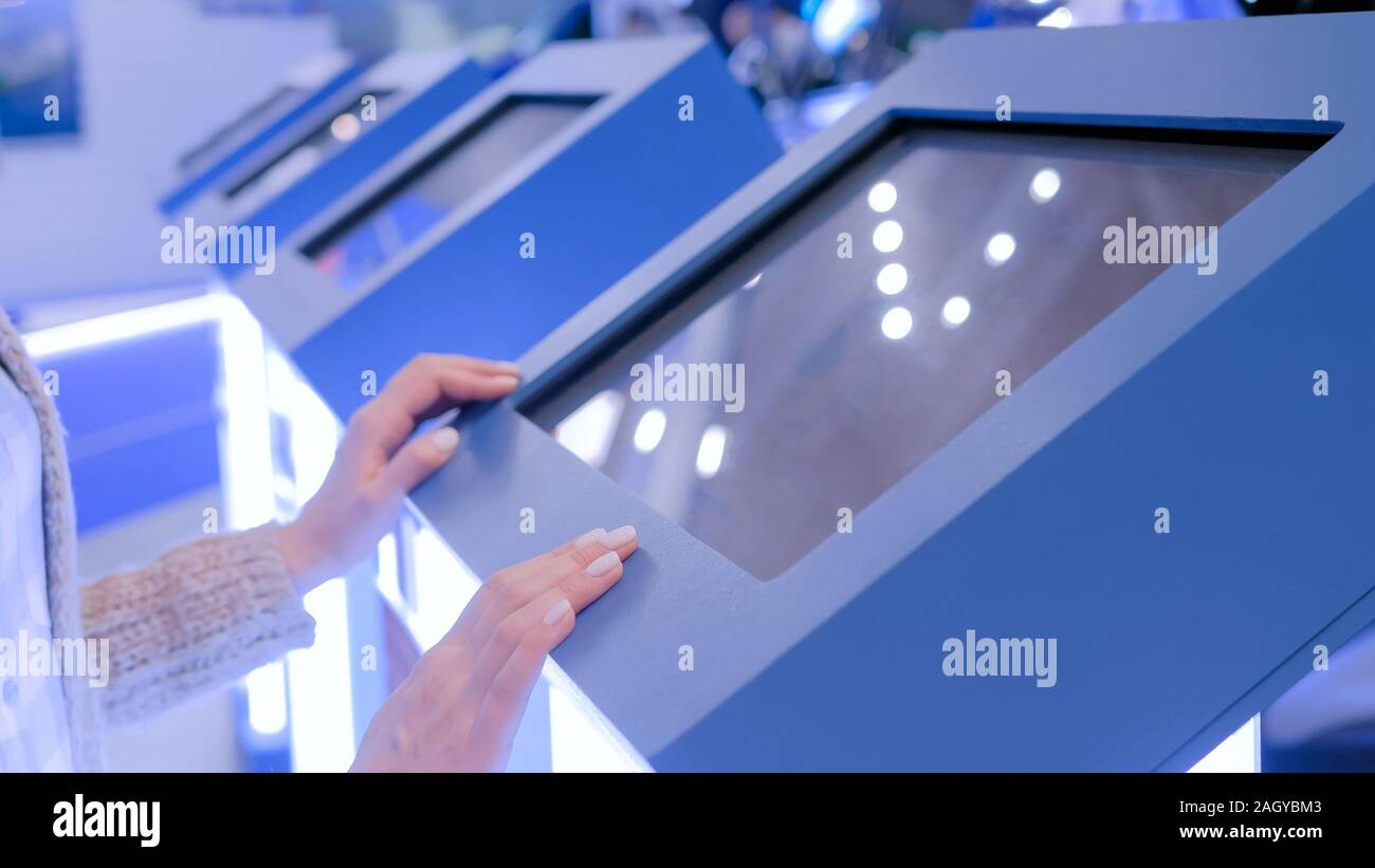 Woman using interactive touchscreen display at technology exhibition ...