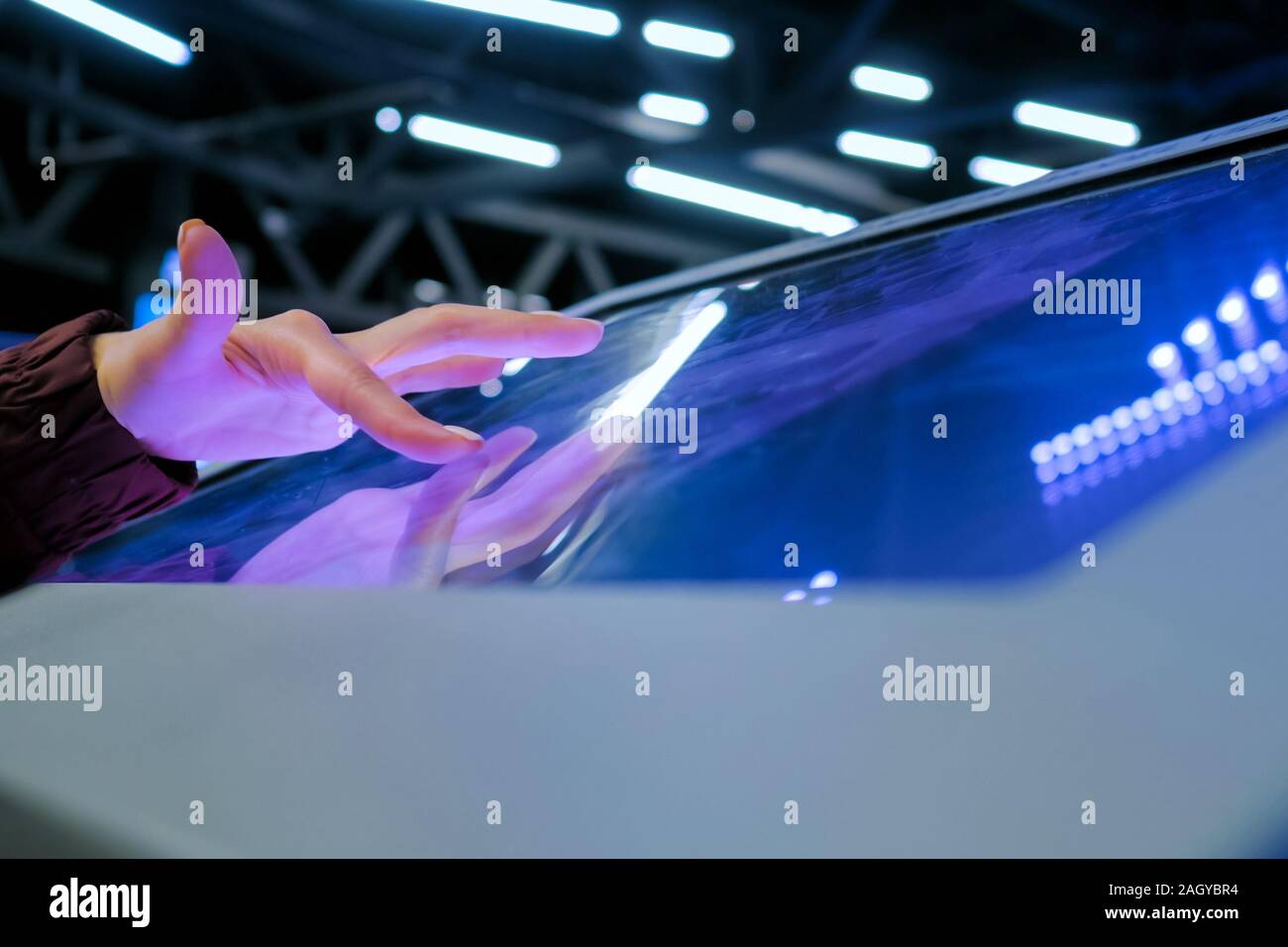 Woman using interactive touchscreen display at technology exhibition ...