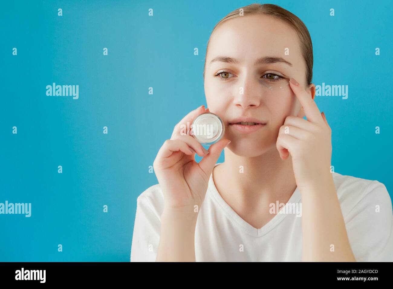 Portrait Of Joyful Girl Covering Her Eye By A Cream Can She Is Looking
