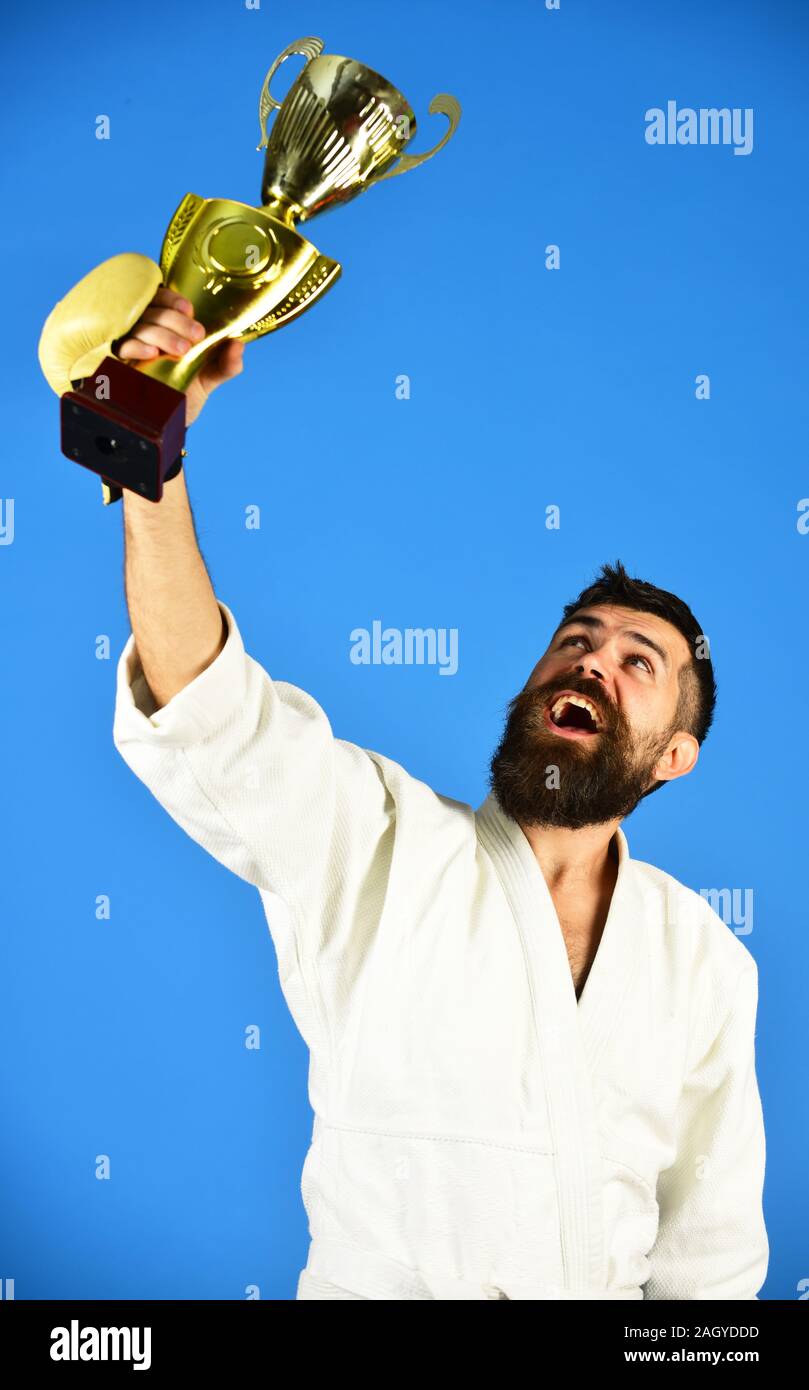 Man with beard in white kimono on blue background. MMA sports concept ...