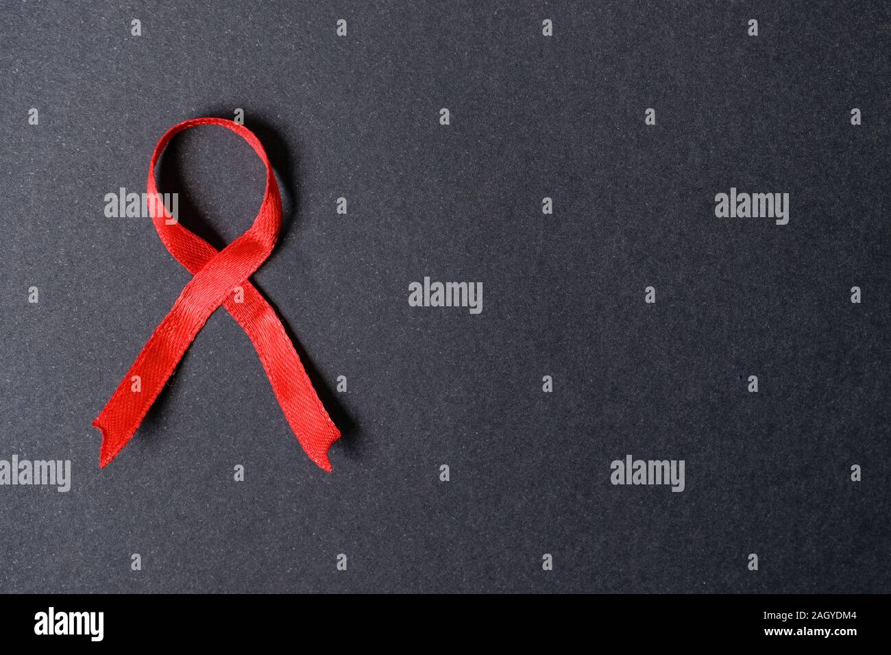 Close up of the red ribbon on black paper background with copy space ...