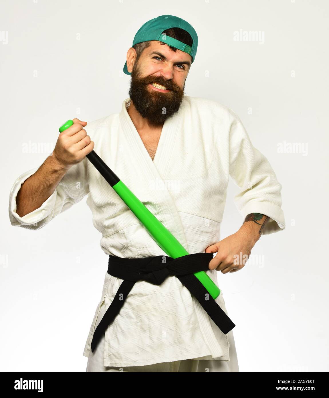 Baseball player with smiling face puts green baseball bat behind black ...