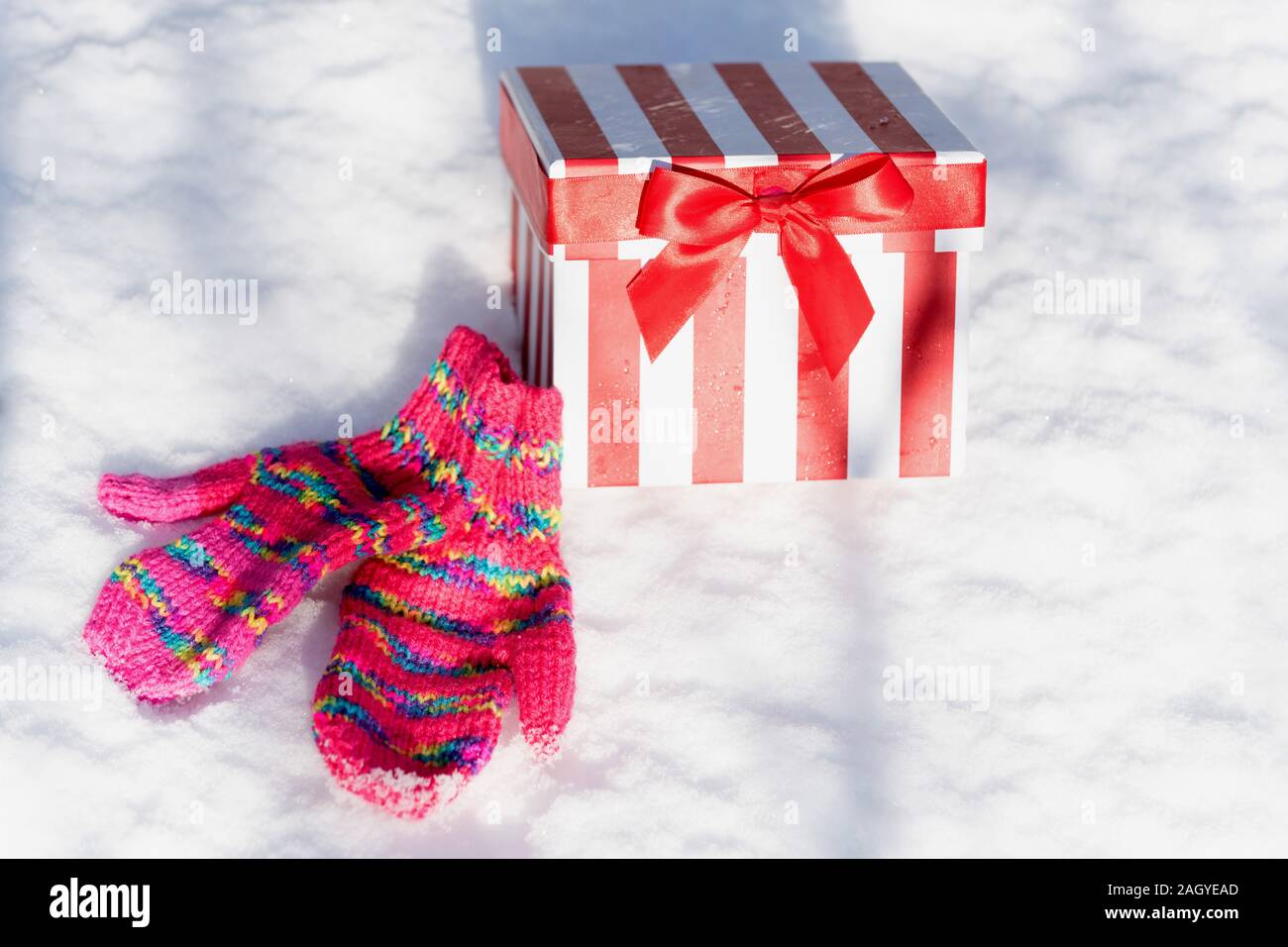 Mittens in red or pink color on snow. Kids or female mittens lying by ...