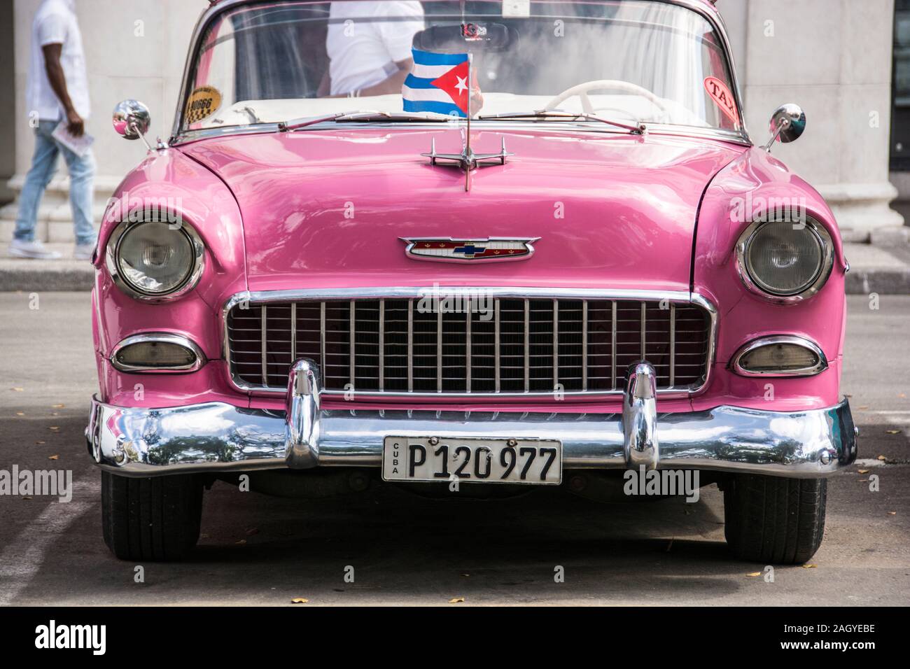A classic, car from the 1950's, hot pink in color, parked in the Old ...