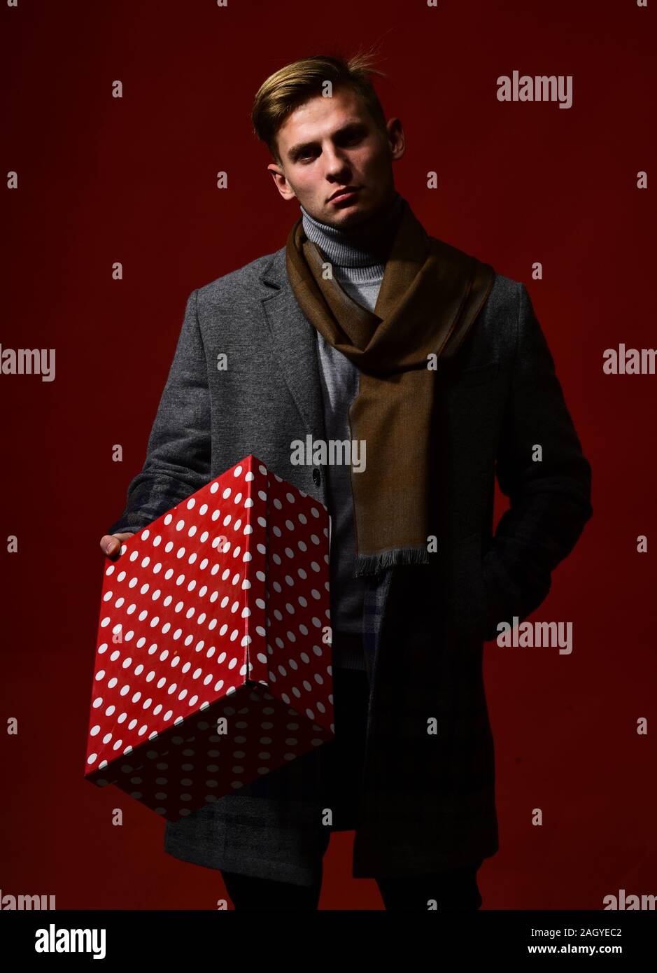 Man in vintage style with present. Guy with brutal face holds bright ...