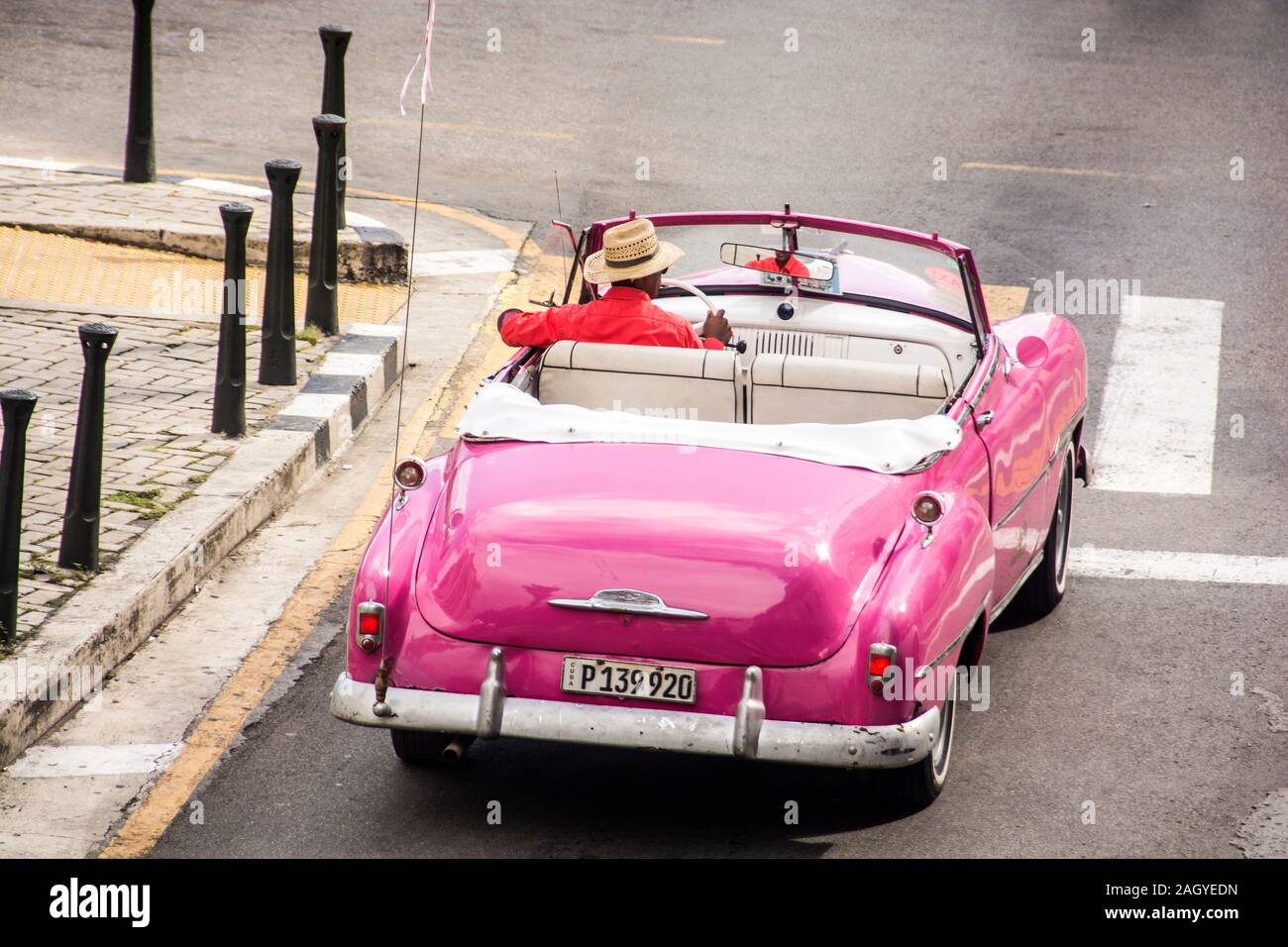A classic, pink car from the 1950's waiting at a stoplight; Old Town ...