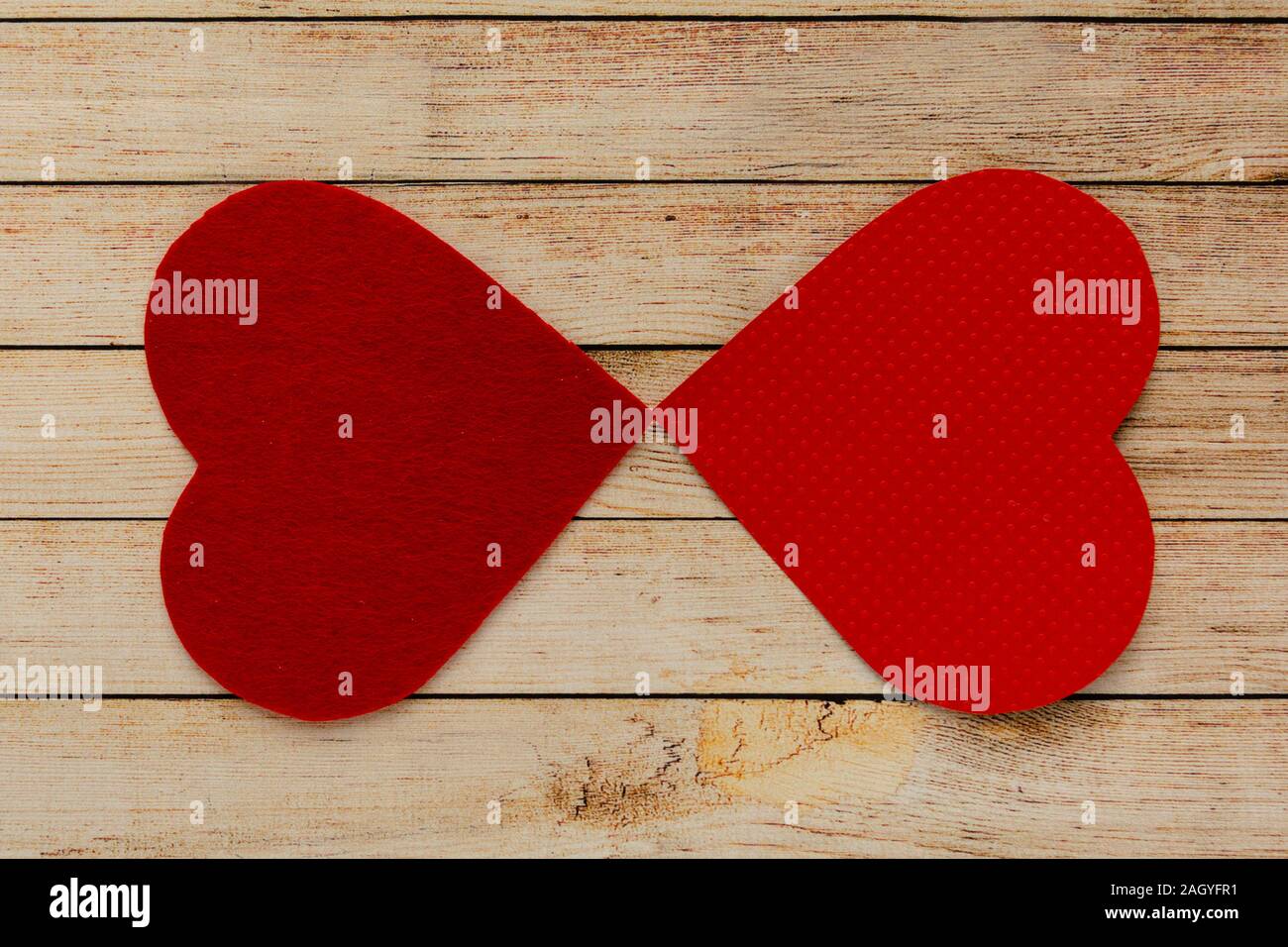 Two red hearts shaped aligned horizontally on wooden background. Top ...