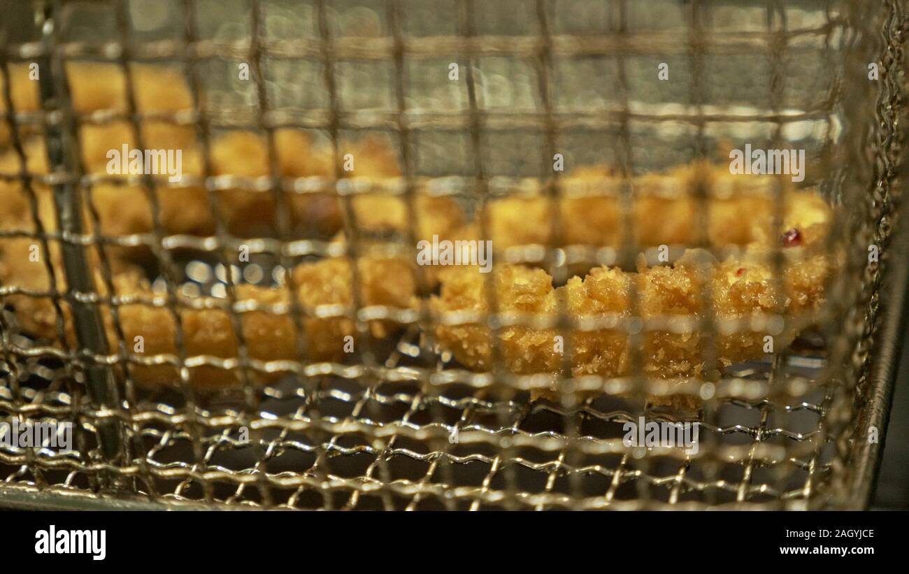 Deep fried onion ring. Oniony Rings cooking in hot bubbly oil in a ...