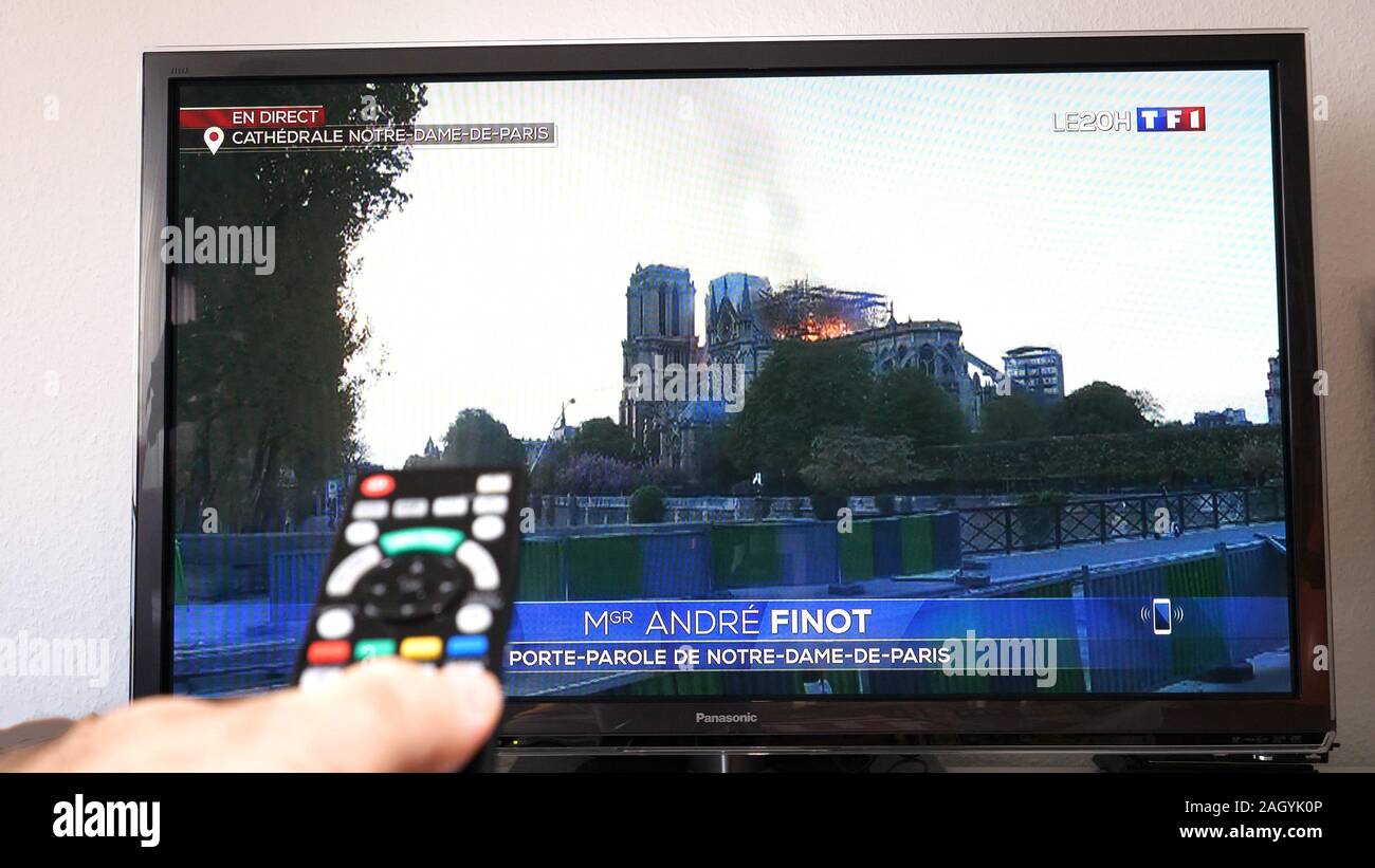 Paris, France - April 15, 2019: Man holding remote control looking at ...