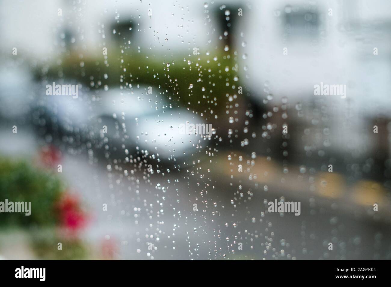 Close-up of glass window surface with rain drops on the outside and ...