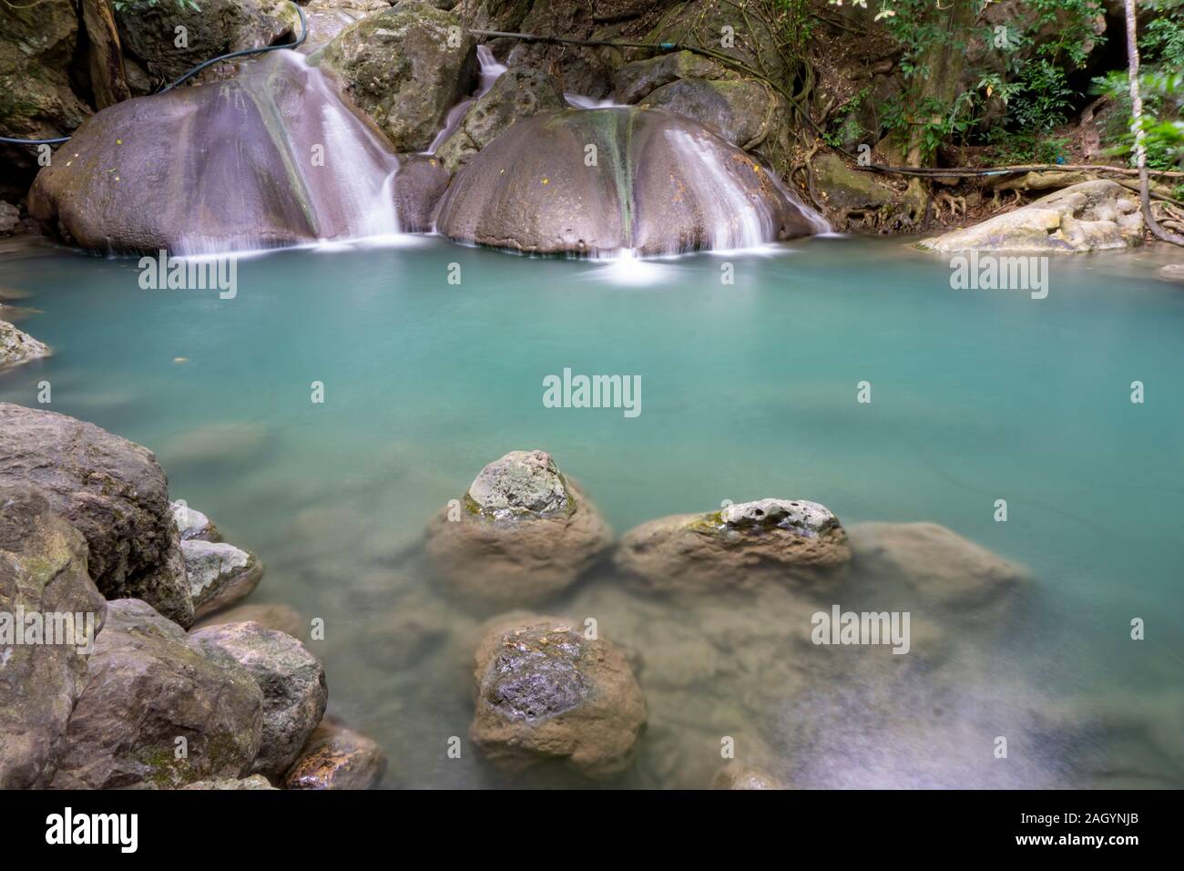 Clean green emerald water from the waterfall Surrounded by small trees ...