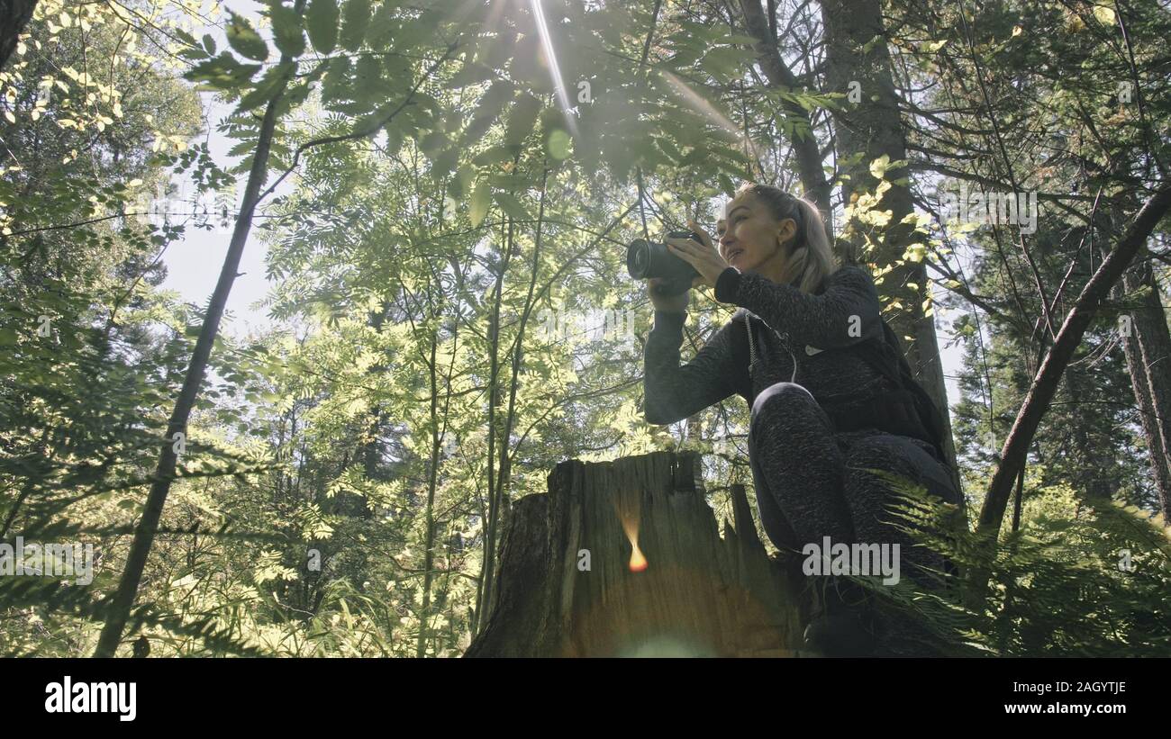Traveler photographing scenic view in forest. One caucasian woman ...