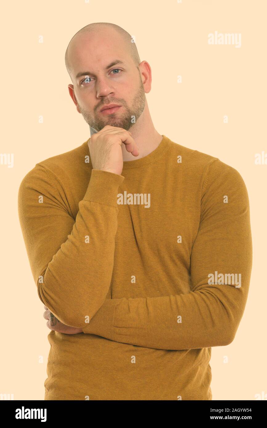 Studio shot of young bald muscular man thinking Stock Photo - Alamy