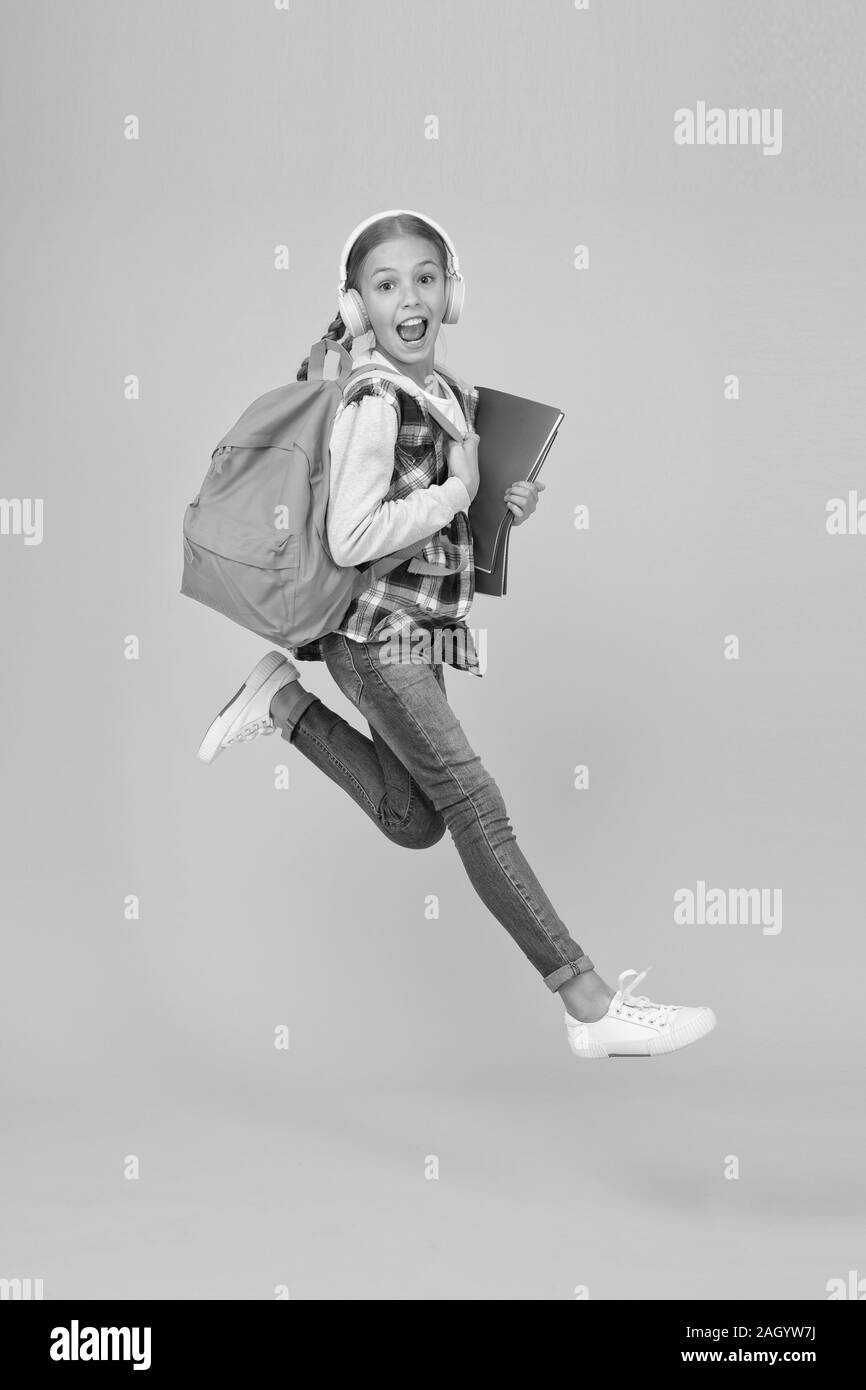 Getting back into studying. Energetic little girl run to school yellow ...