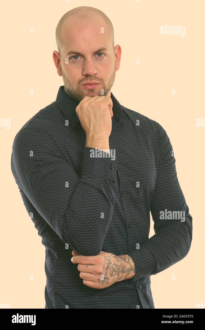 Studio shot of young bald muscular man thinking Stock Photo - Alamy