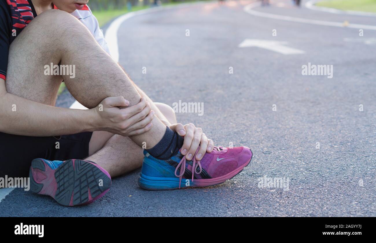 Ankle sprained. Young man suffering from an ankle injury while running ...