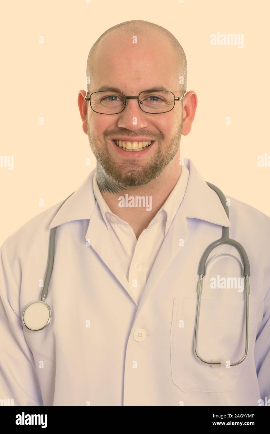 Face of young happy bald muscular man doctor smiling while wearing ...