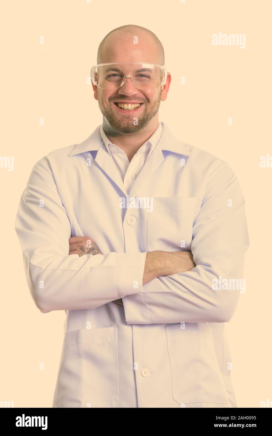 Studio shot of young happy bald muscular man doctor smiling while ...