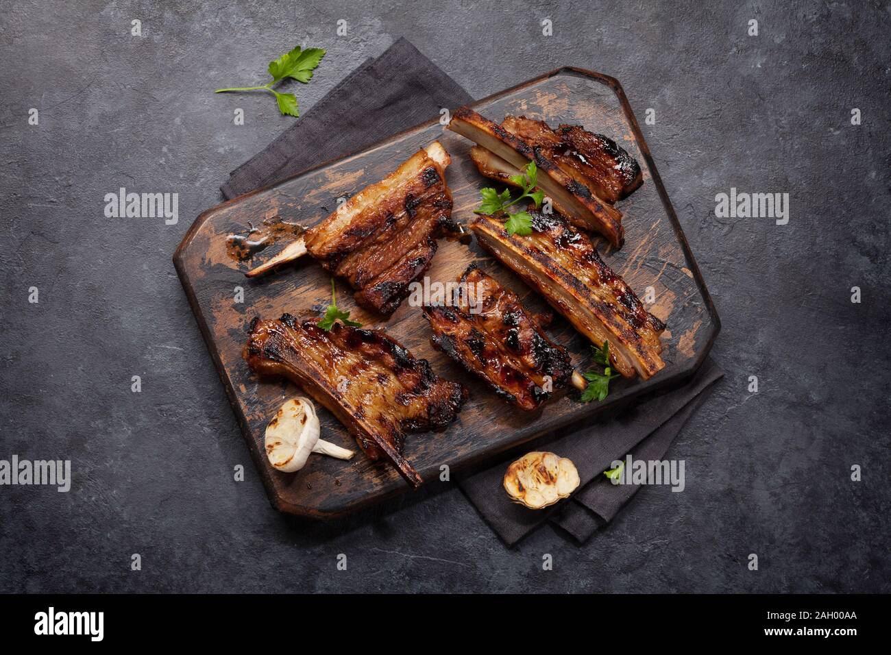 Barbecue beef ribs with bbq sauce sliced on a wooden board. Top view ...
