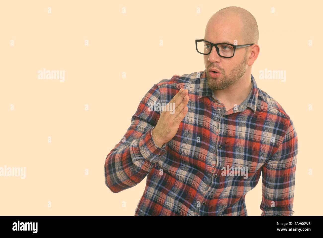 Studio shot of young bald muscular man looking shocked Stock Photo - Alamy