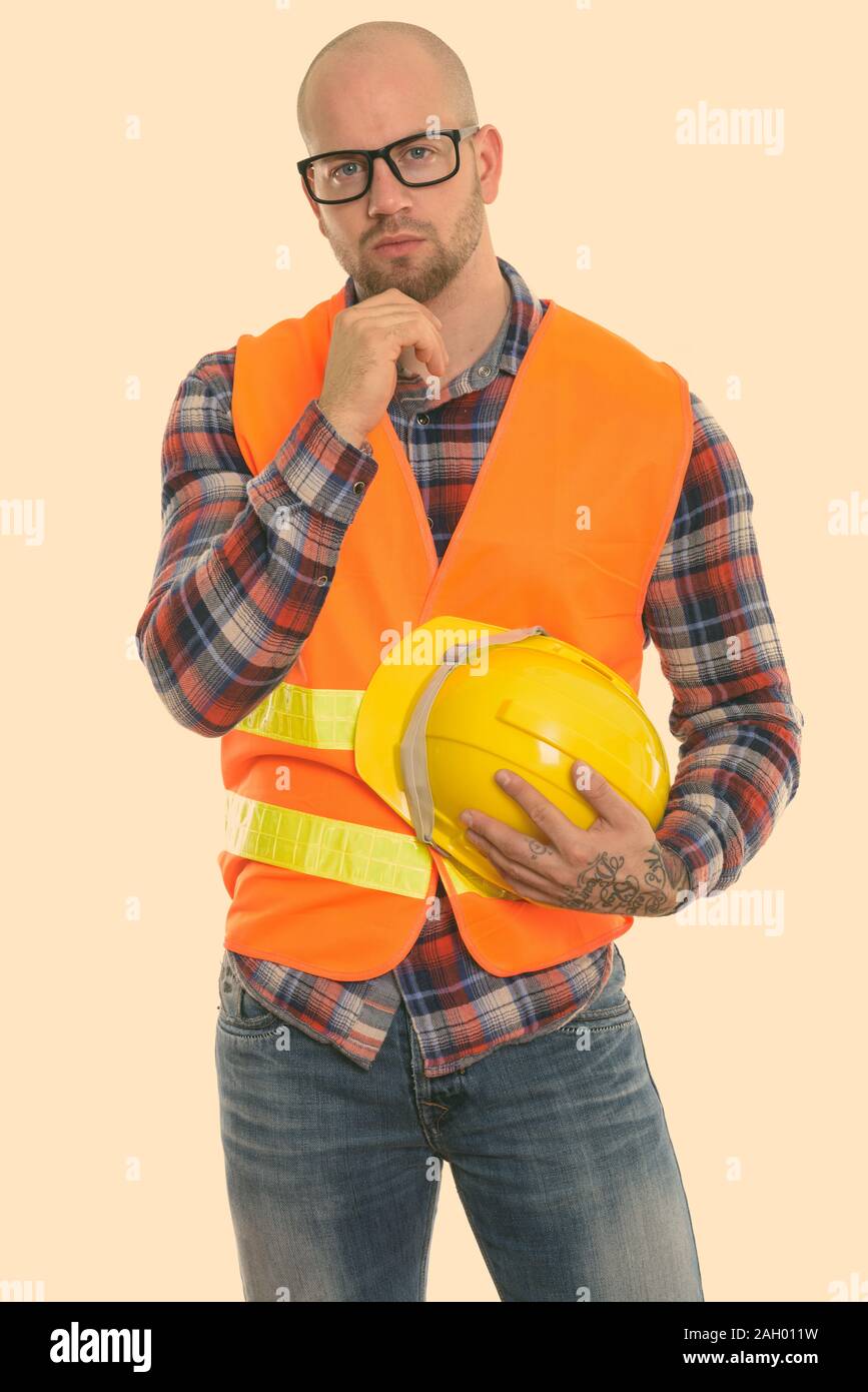 Bald muscular man construction worker thinking while holding safety ...