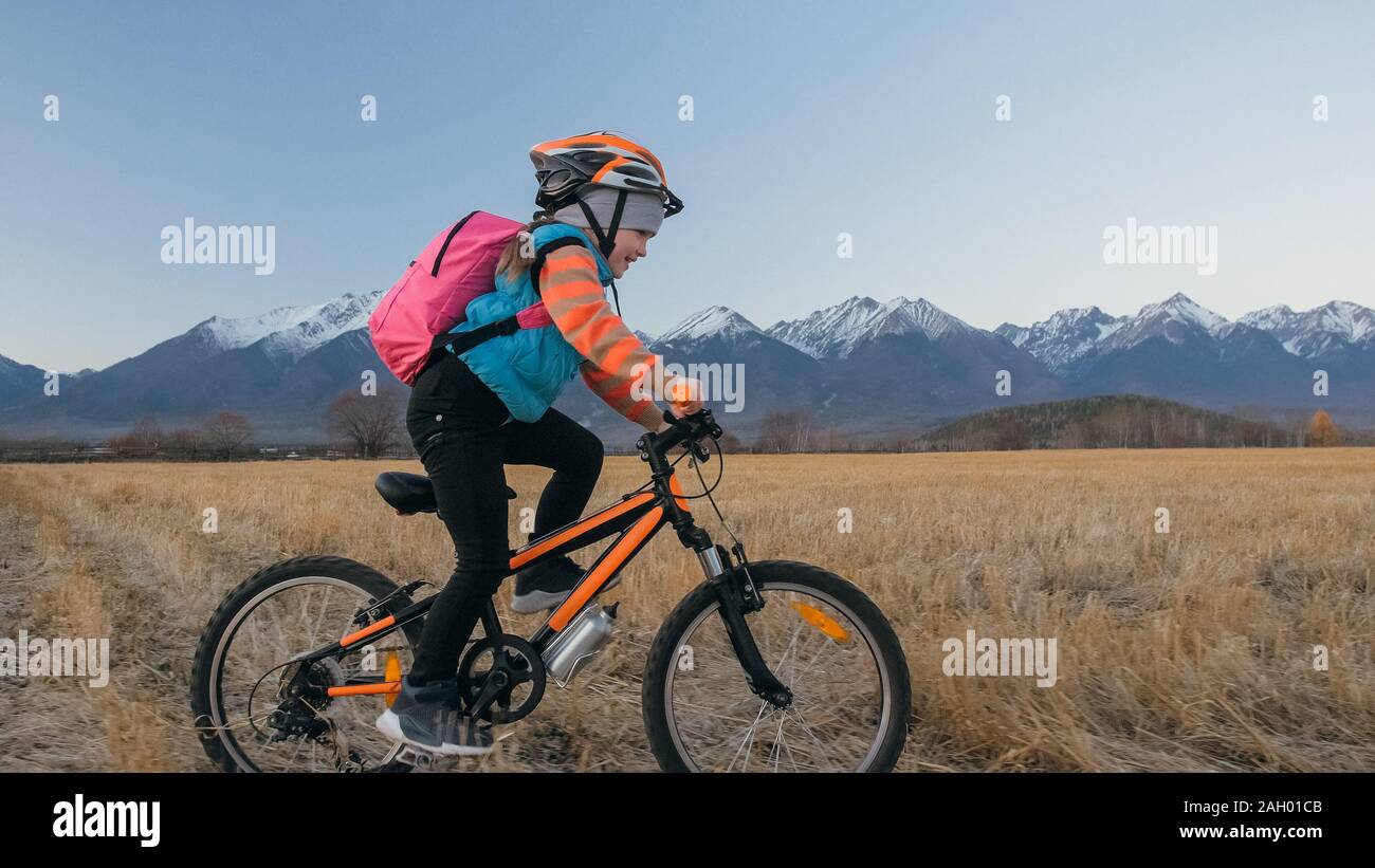 One caucasian children rides bike in wheat field. Little girl riding ...