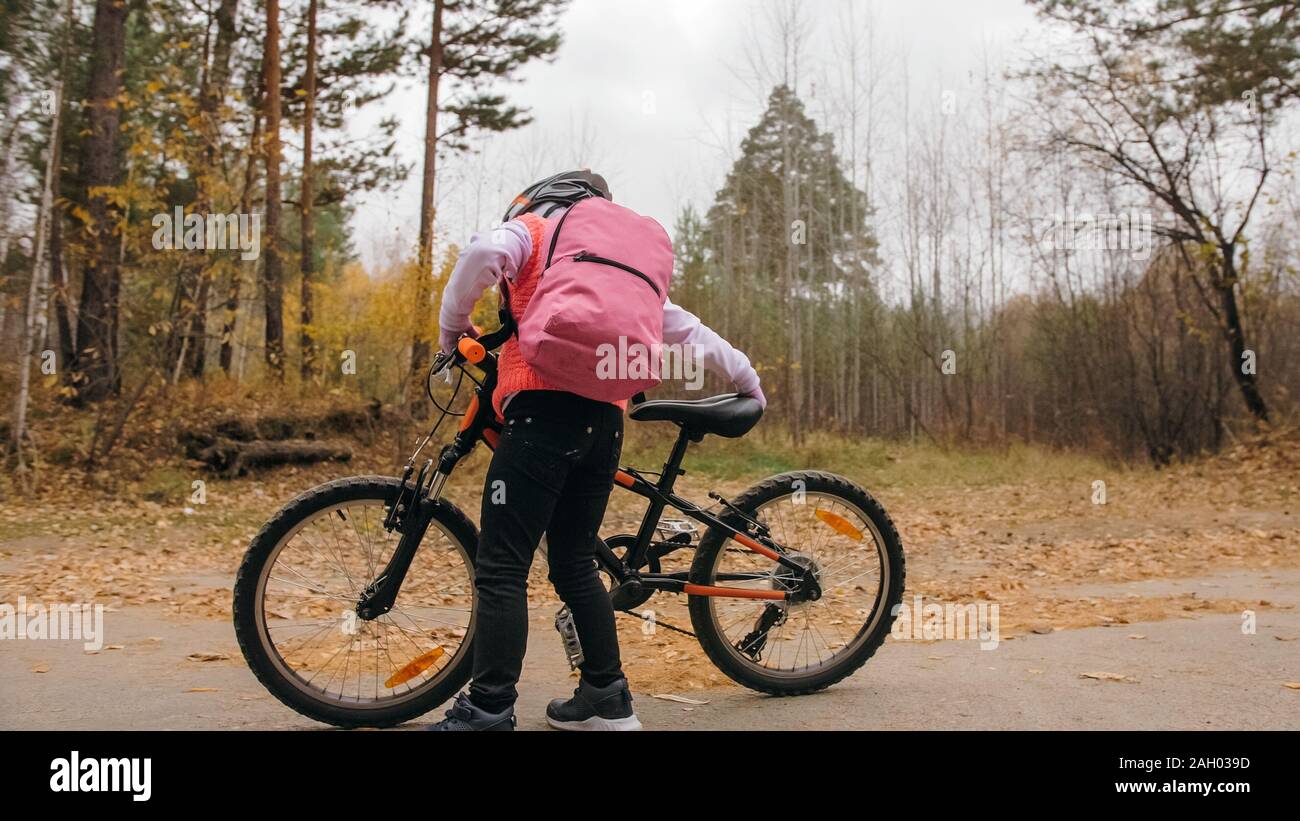 One caucasian children walk with bike in autumn park. Little girl ...