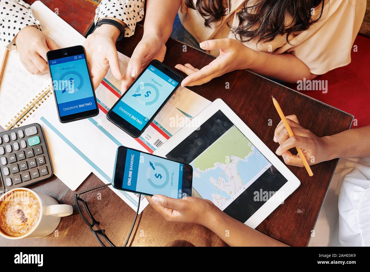 Group of female friends using banking application when paying for plane ...