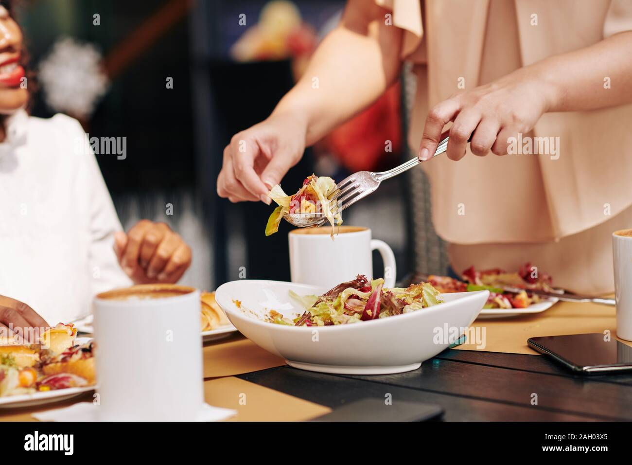 Woman putting plates on table hi-res stock photography and images - Alamy