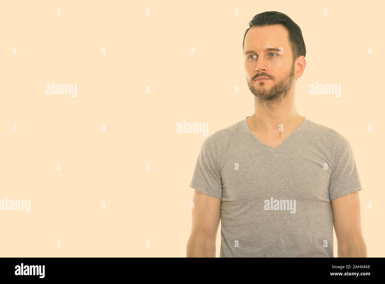 Studio shot of young man thinking while looking at distance Stock Photo ...