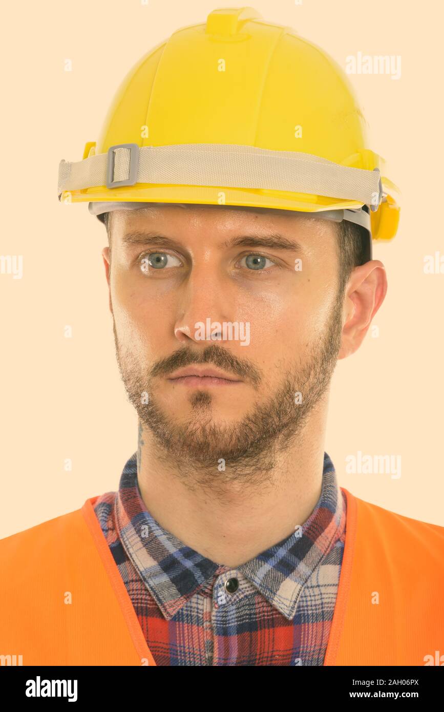 Face of young man construction worker thinking while looking at ...