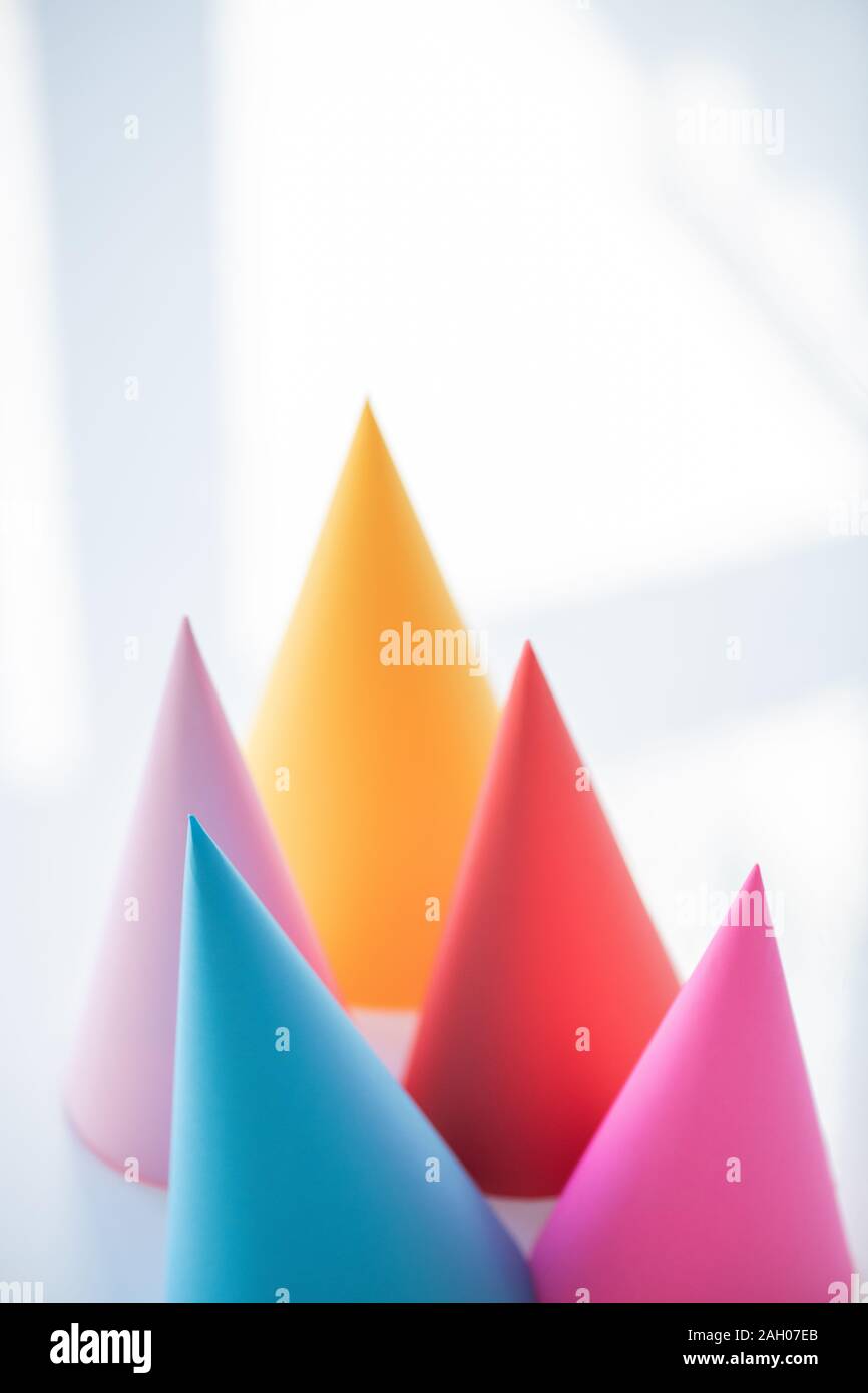 Five colorful cones made up of orange, violet, red and blue paper ...