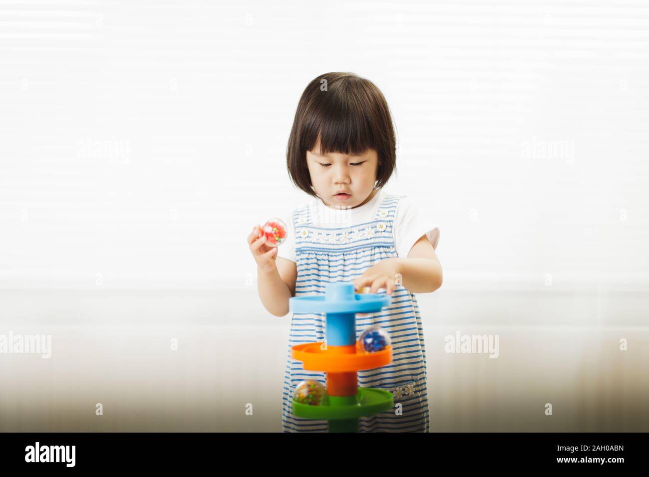 toddler girl play stack ball game at home Stock Photo - Alamy