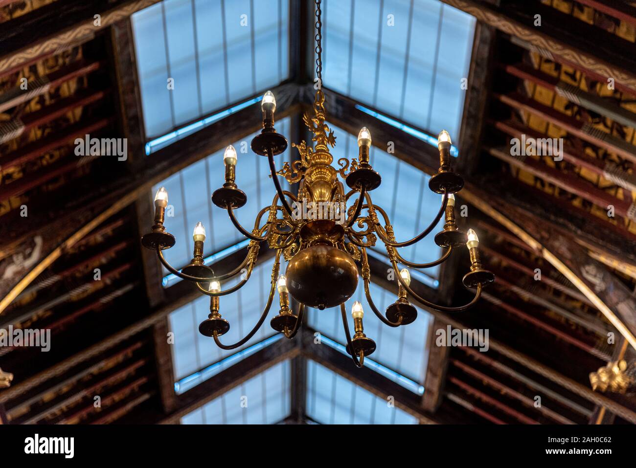 Beautiful enlightened golden chandelier hanging under blurred ceiling ...