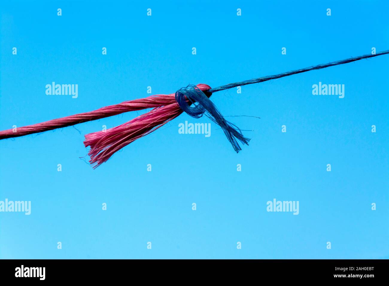 Closeup of red and blue ropes under the sunlight against a blue sky at ...