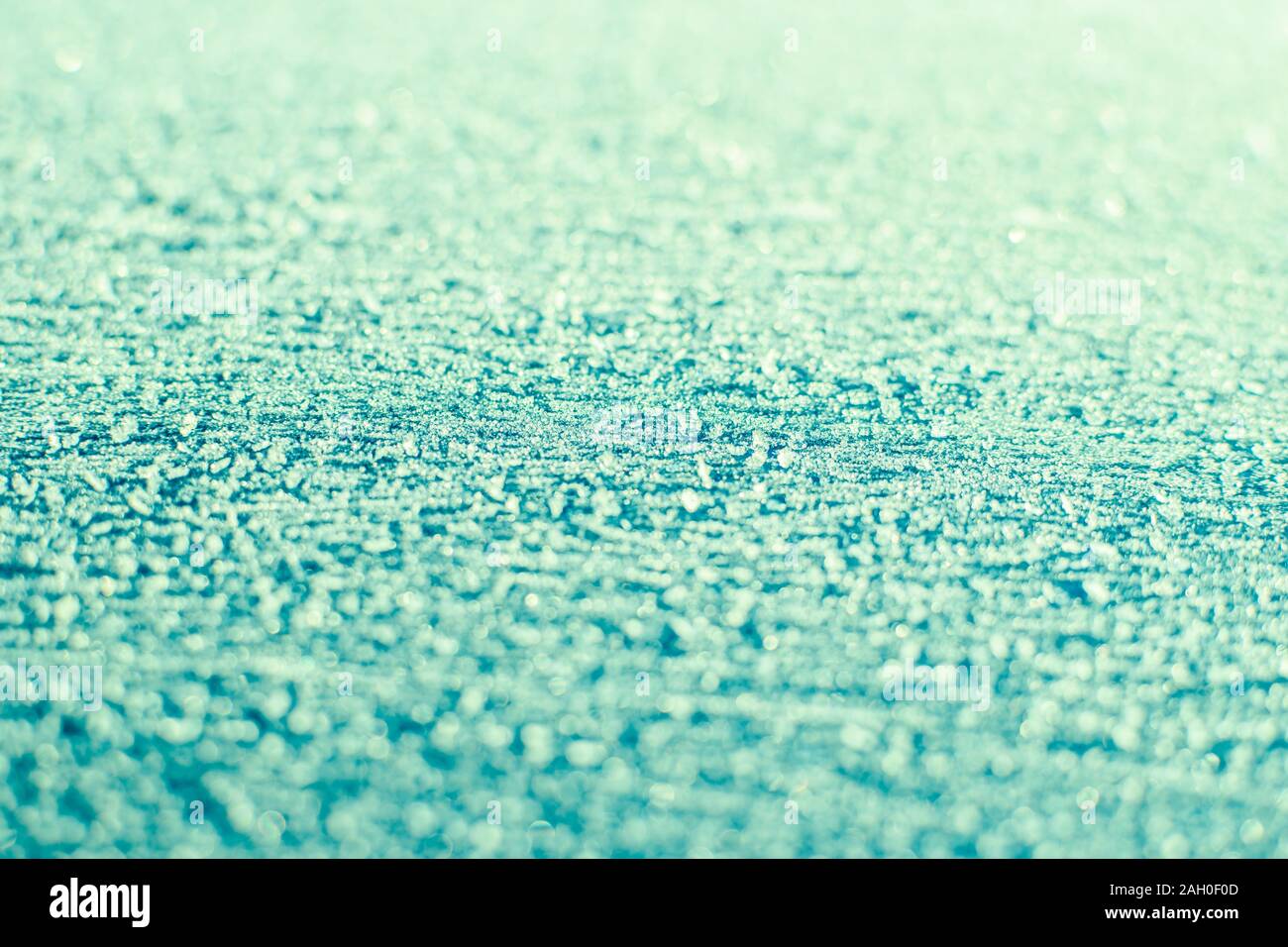 Texture of sparkling first cold ice. Snowy backdrop in green colors ...