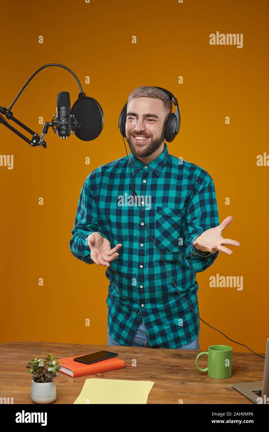 Vertical medium long shot portrait of young adult radio broadcaster ...