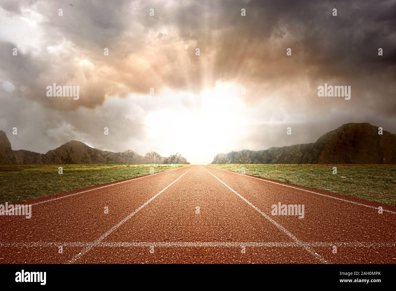 Running track with green grass and mountain view with sunlight ...
