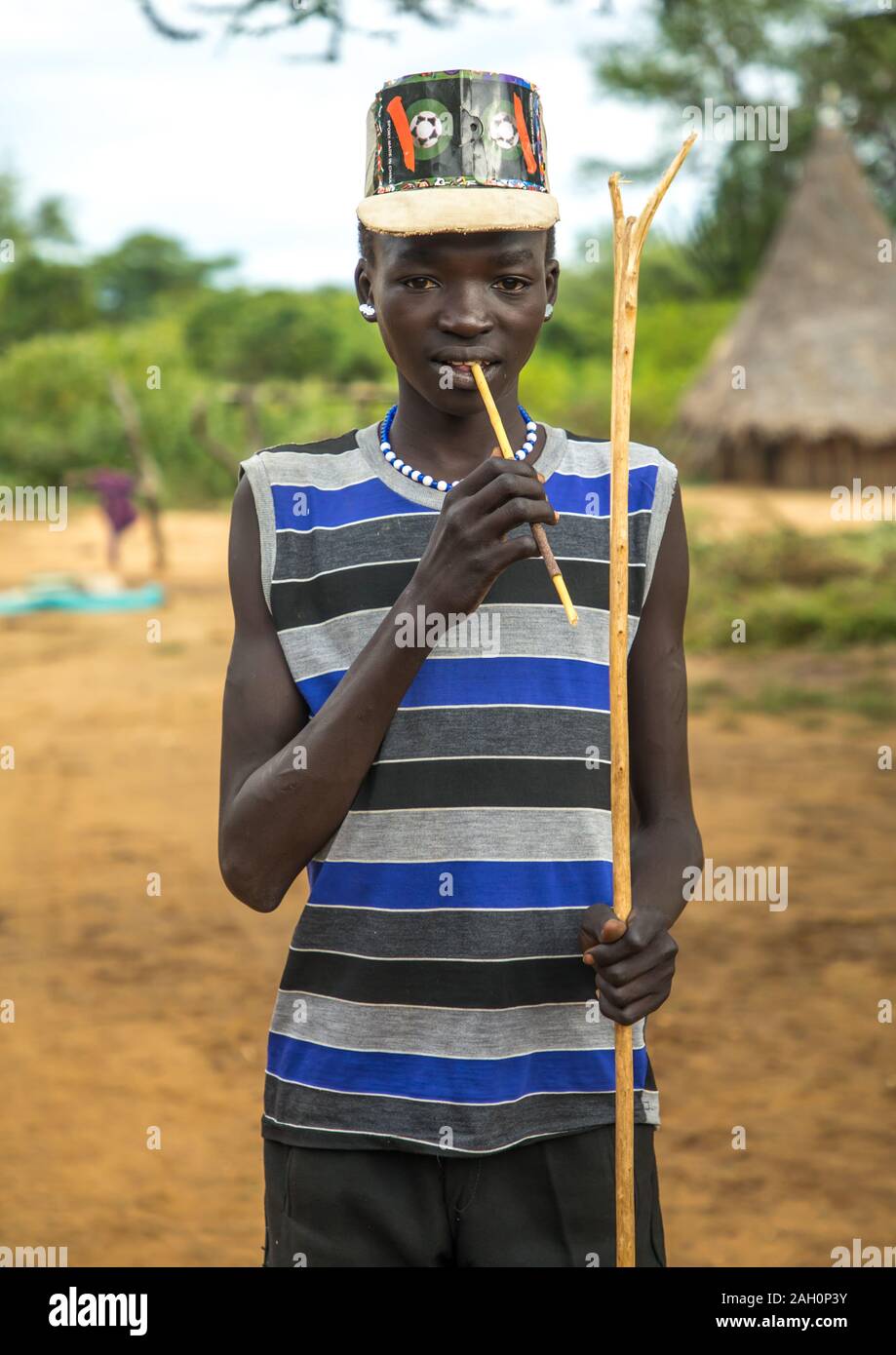 Larim tribe boy with a fashionnable look using a wooden toothbrush ...