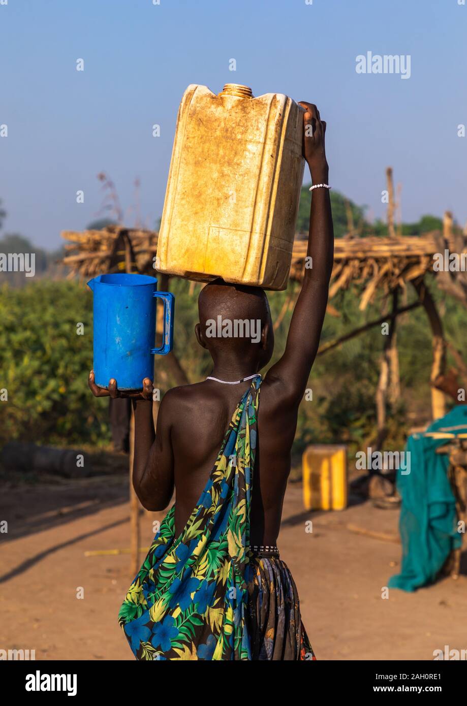 Mundari tribe woman carrying a yellow jerrican on the head, Central ...