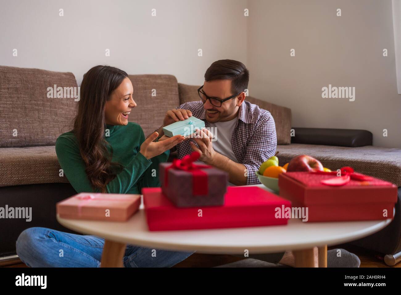 Happy couple is sharing gifts in their home Stock Photo - Alamy