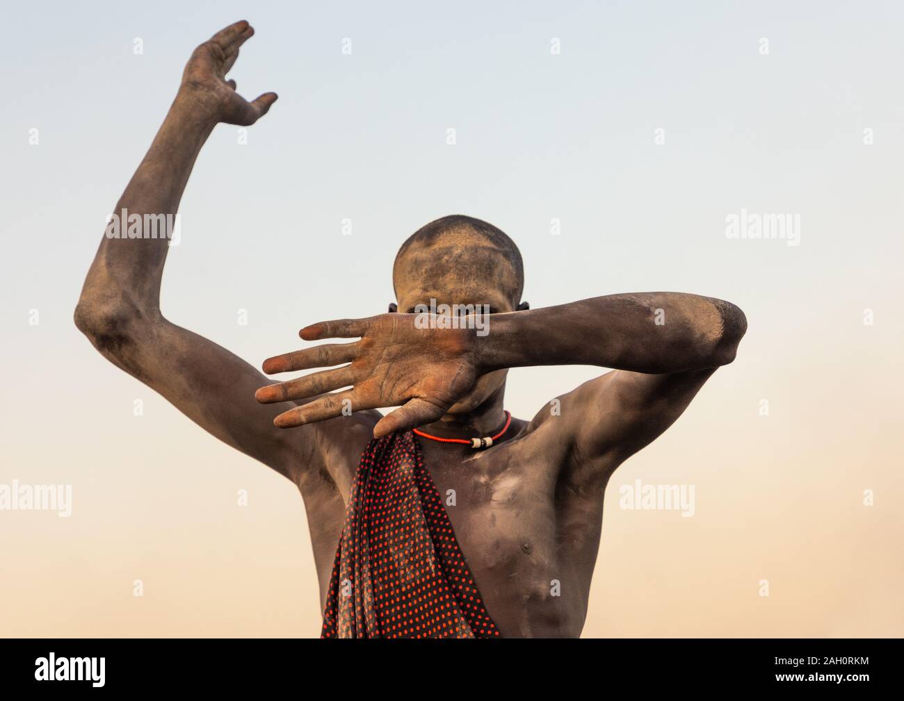 Portrait of a Mundari tribe man mimics the position of horns of his favourite cow, Central ...