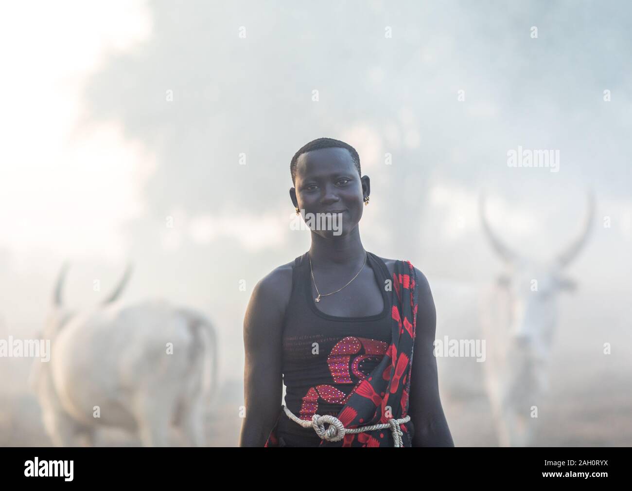 Mundari tribe woman with long horns cows in a camp, Central Equatoria ...