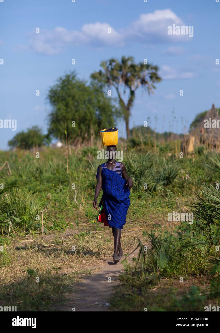 Mundari tribe woman carrying a yellow jerrican on the head, Central ...