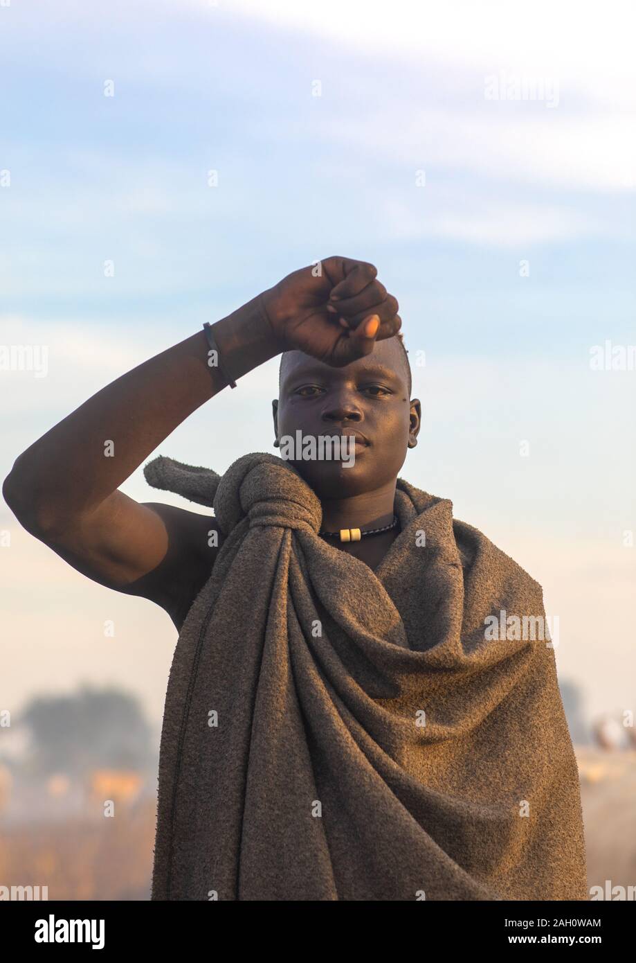 Portrait of a Mundari tribe man mimics the position of horns of his favourite cow, Central ...