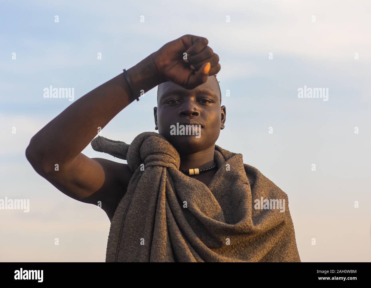 Portrait of a Mundari tribe man mimics the position of horns of his favourite cow, Central ...