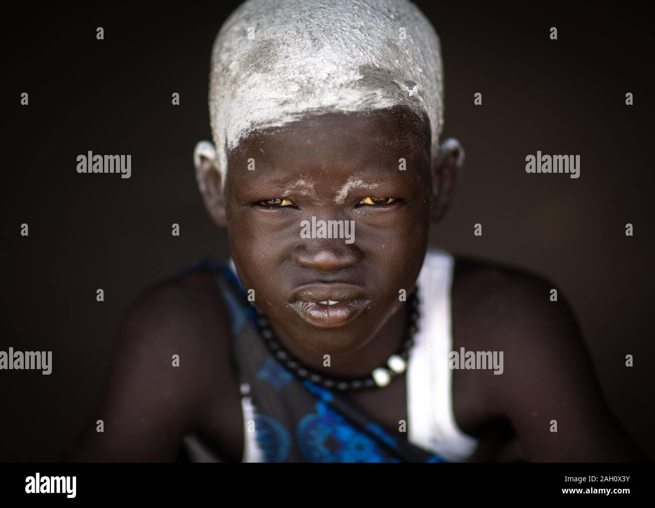 Portrait of a Mundari girl with ash on the head to dye her hair in red ...