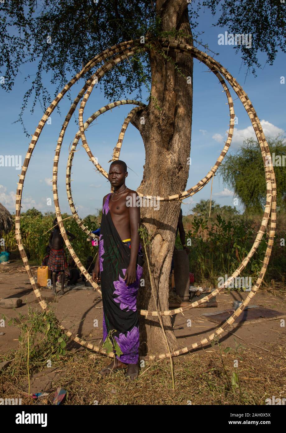 Portrait of a Mundari tribe woman in front of stuff used to build the ...