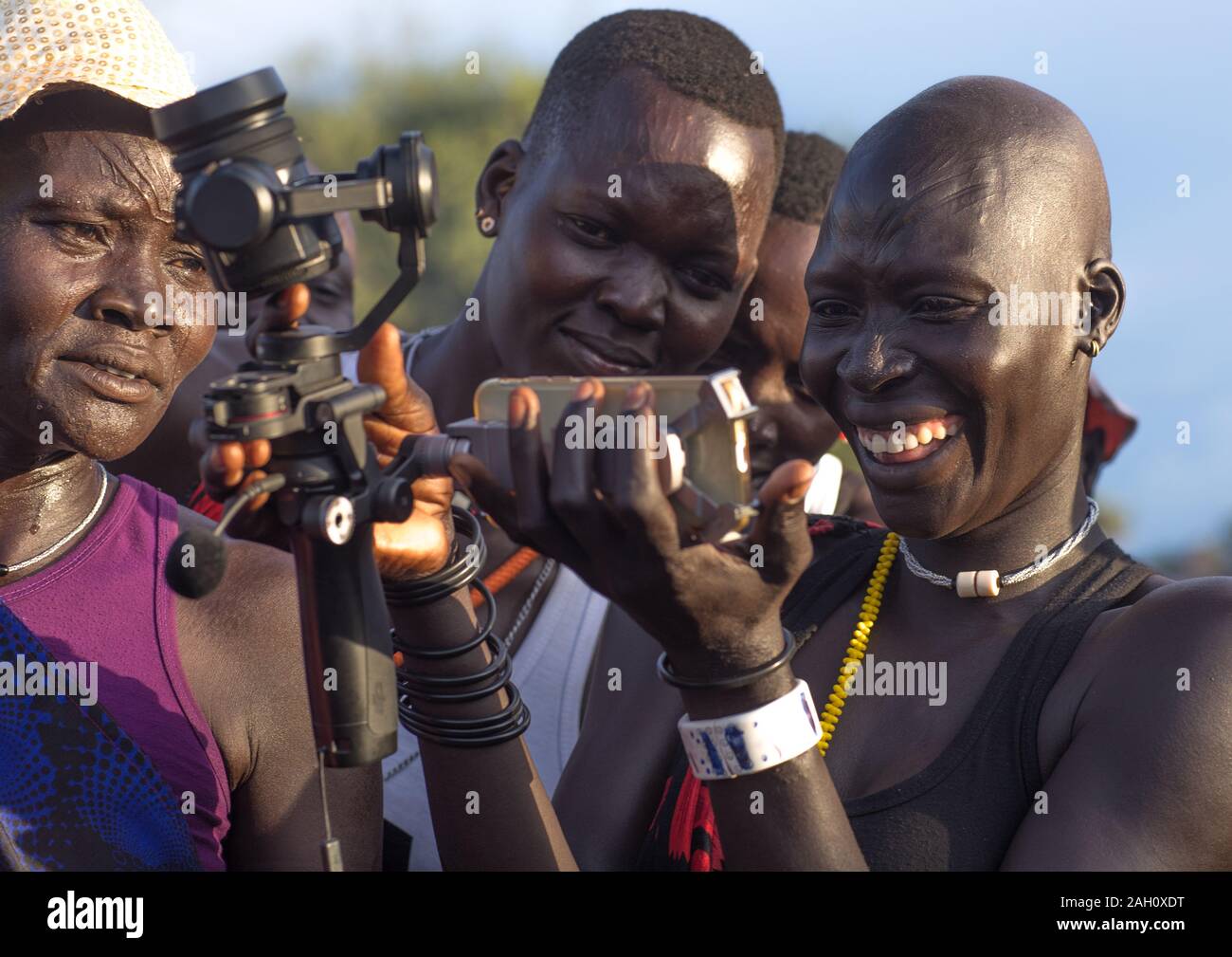 Mundari tribe women laughing while watching themsleves on the screen of ...